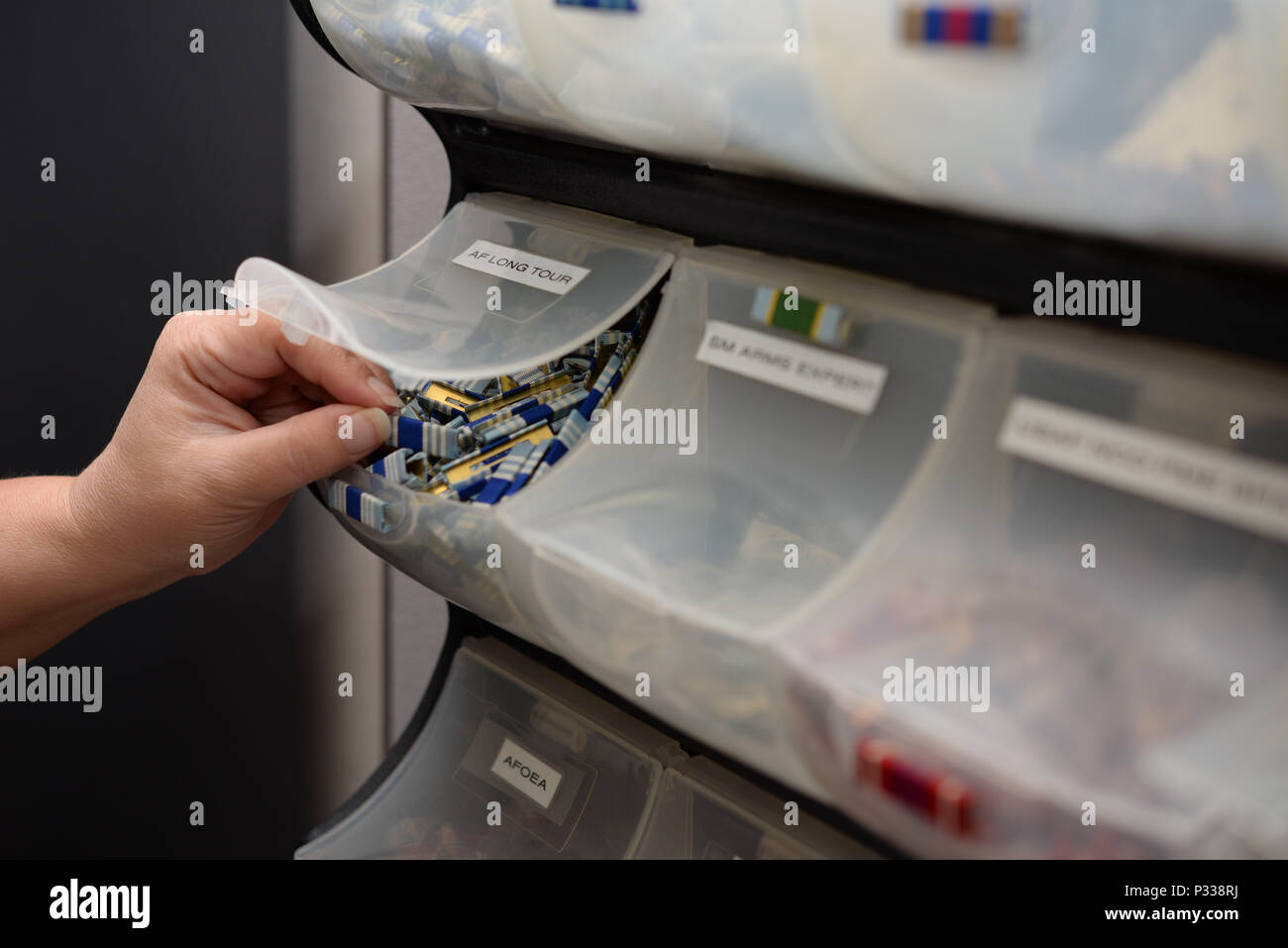 A member with the Military Personnel Flight takes a ribbon from a ...