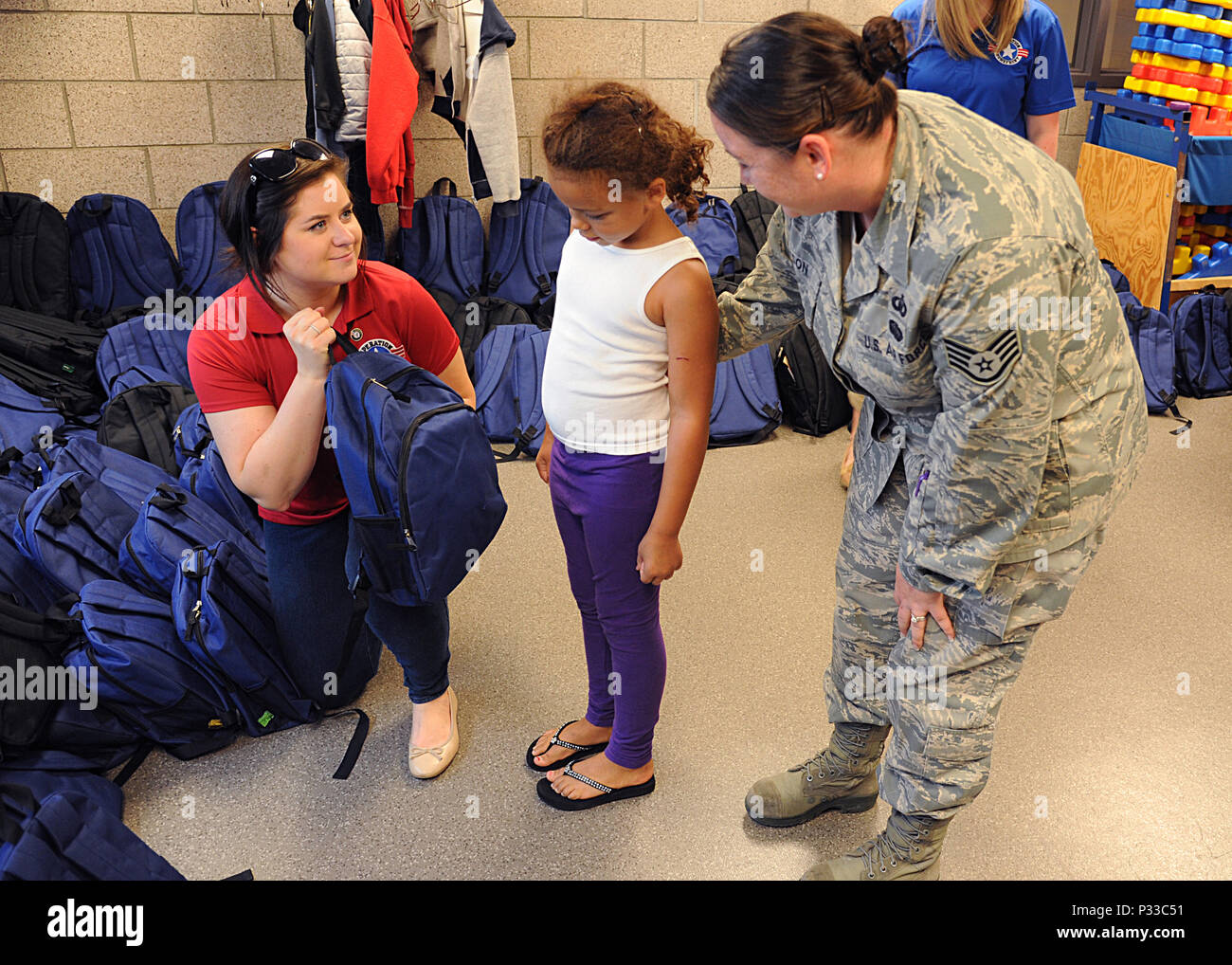 Operation Homefront volunteer Taylor Zanotti, left, hands a backpack ...