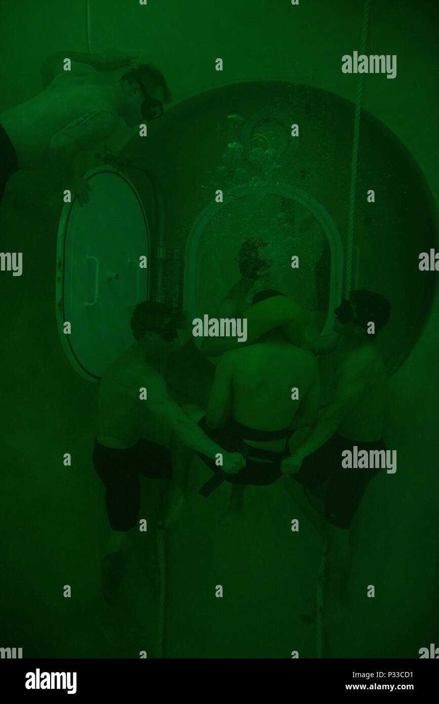 Sailors attached to the Pressurized Submarine Escape Trainer watch as a ...