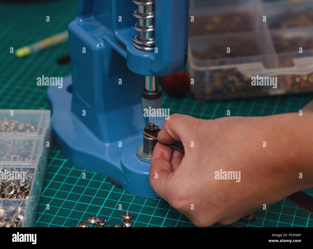 Tanner fastens rivet to leather bracelet. Close-up photo. Rivet gun ...