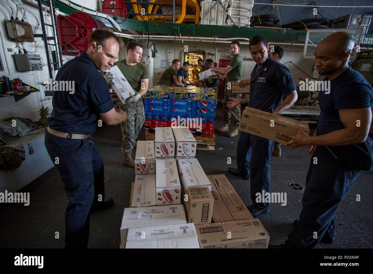 U.S. Marines and Sailors pass boxes during a replenishment at sea ...