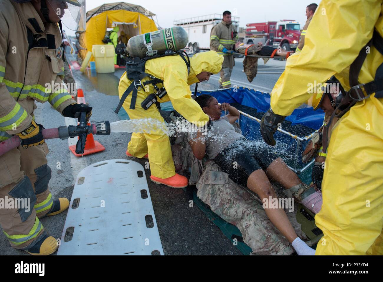 Firefighters decontaminate a role-player with simulated injuries during ...
