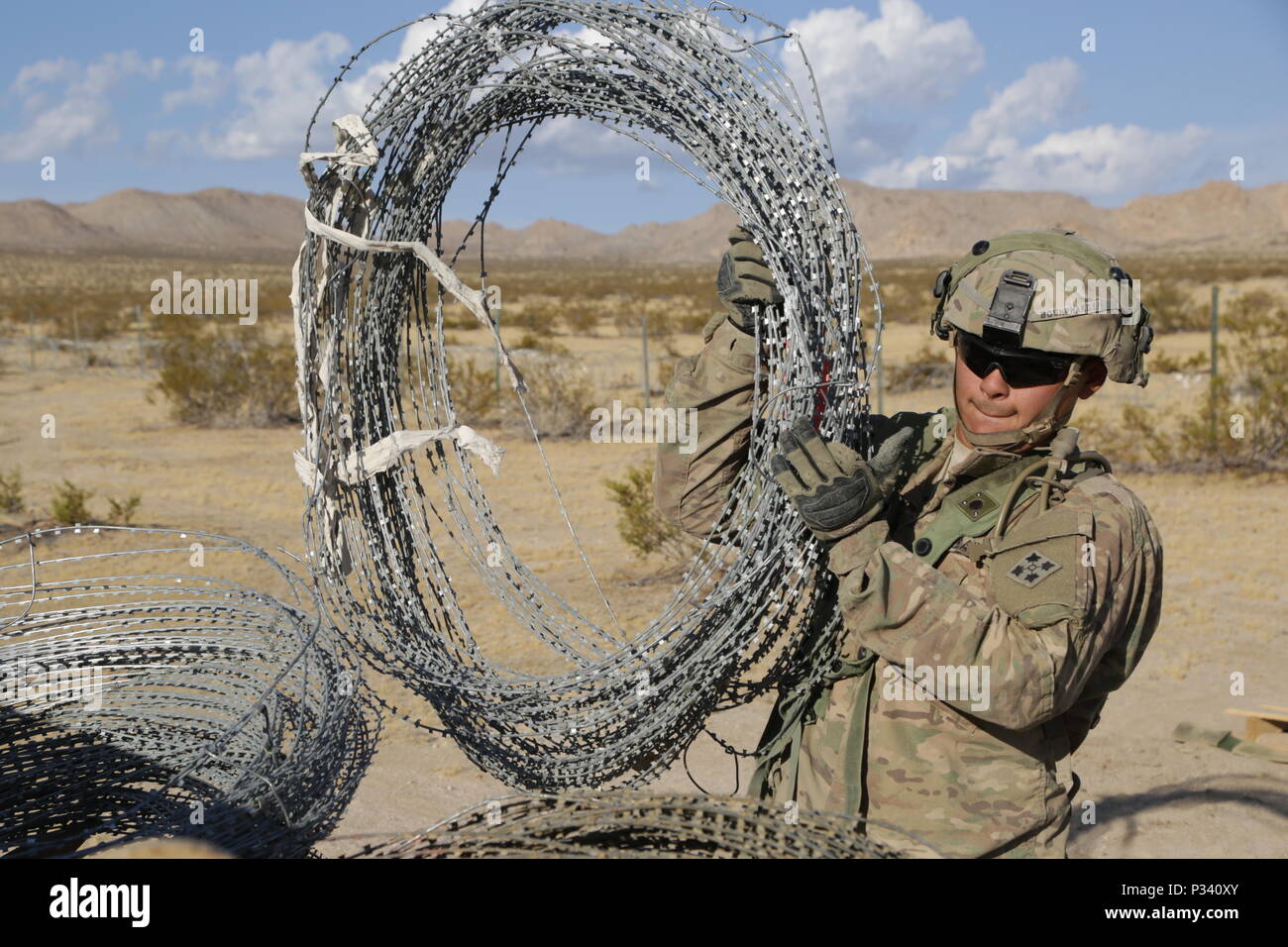 U.S. Soldier assigned to 588th Engineer Battalion loads concertina wire ...