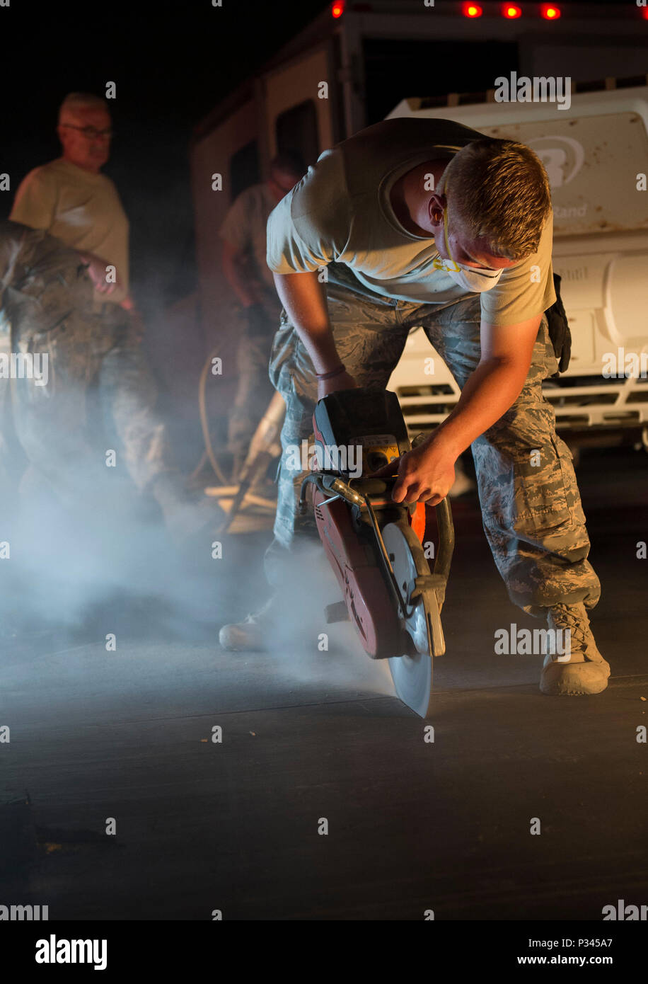 A Civil Engineer Airman cuts a damaged section of airfield for a repair ...
