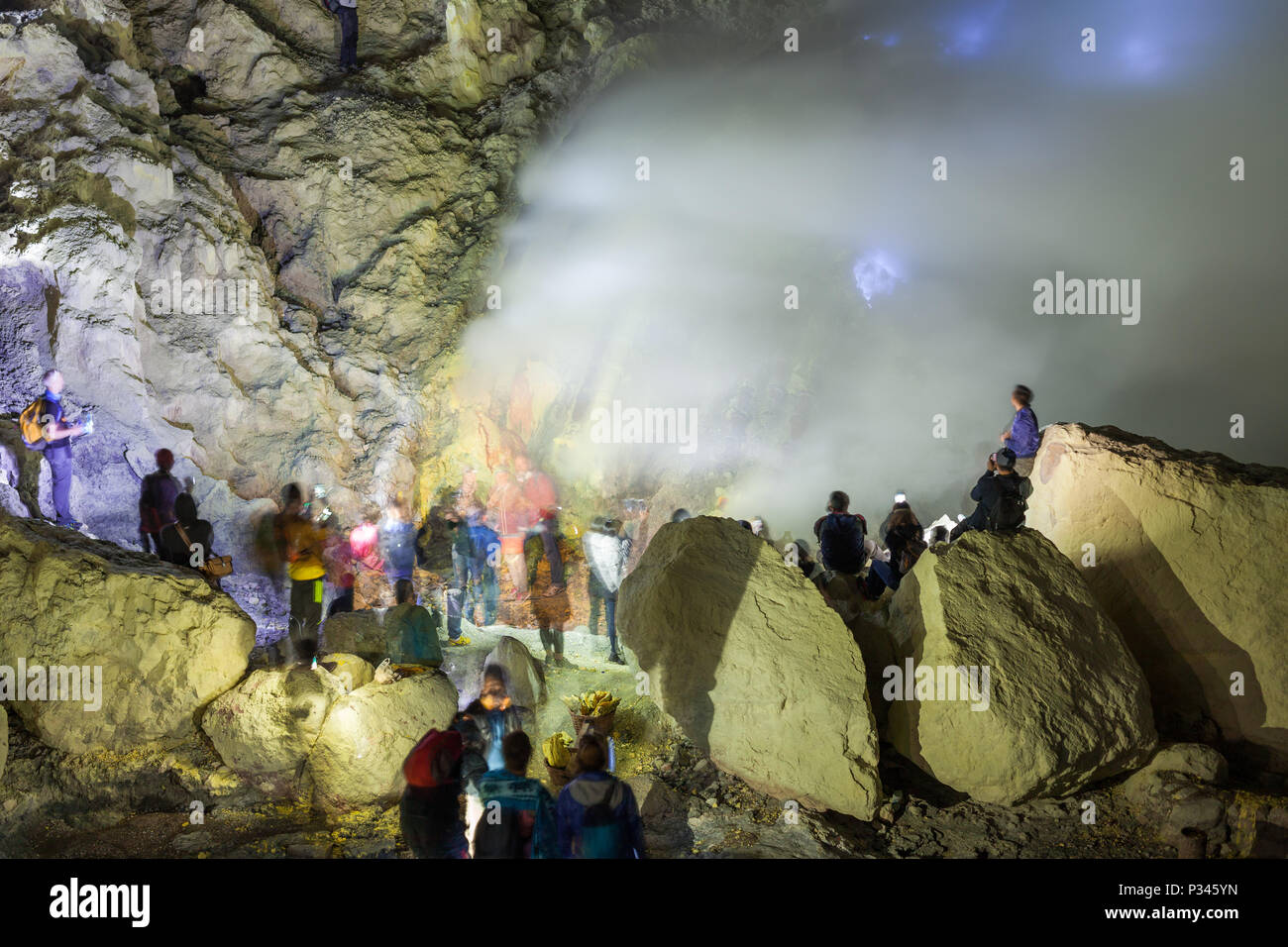 Tourists watch the blue fire of sulphur flames in the Ijen volcano ...