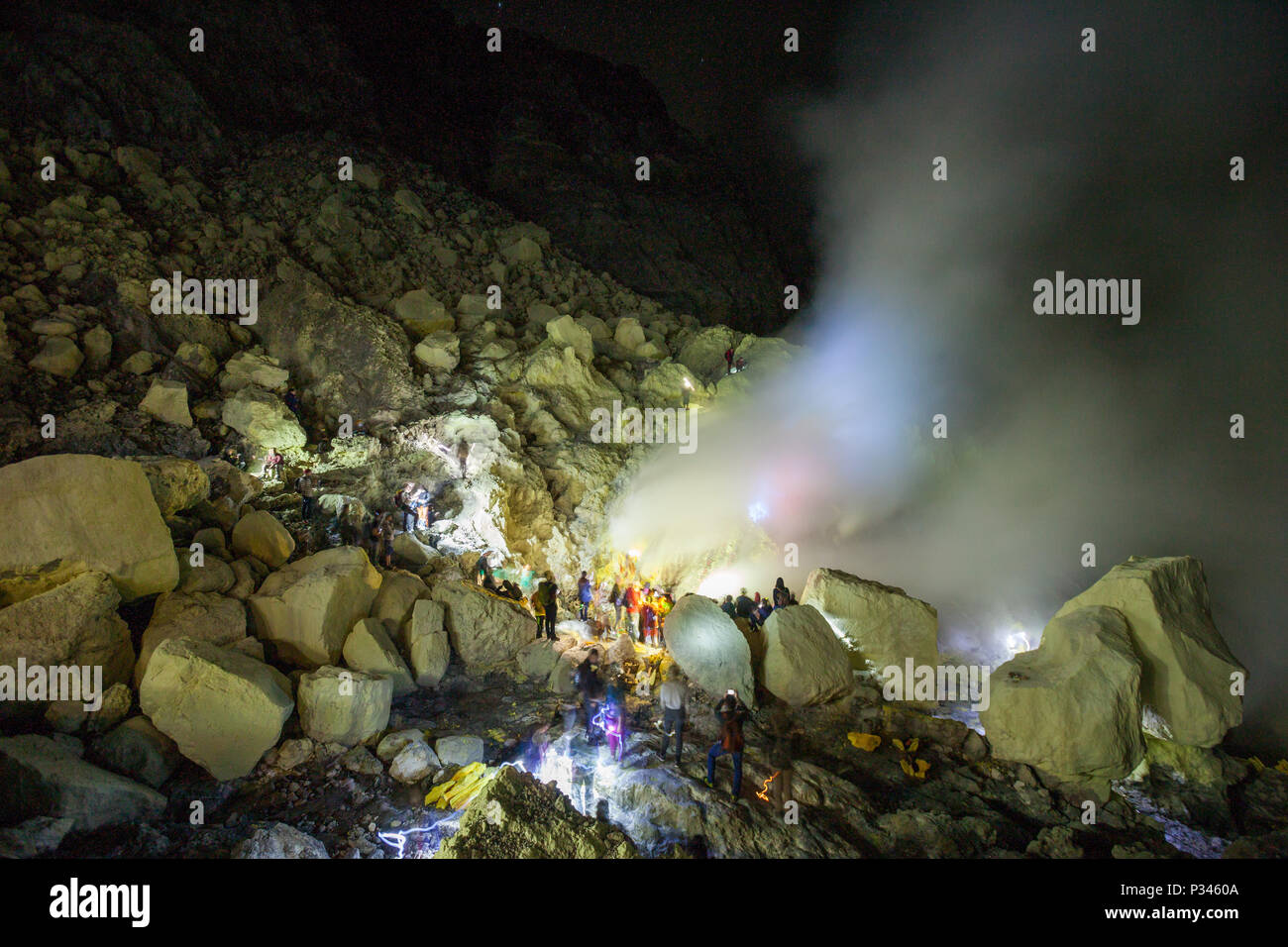 Tourists watch the blue fire of sulphur flames in the Ijen volcano ...