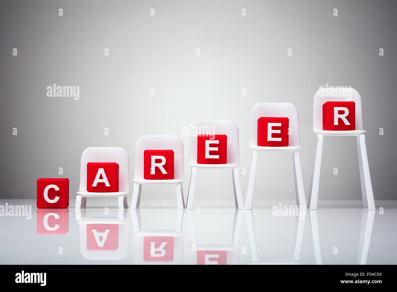 Red Cubic Blocks With Career Word On Increasing Scale Of Chairs Over ...