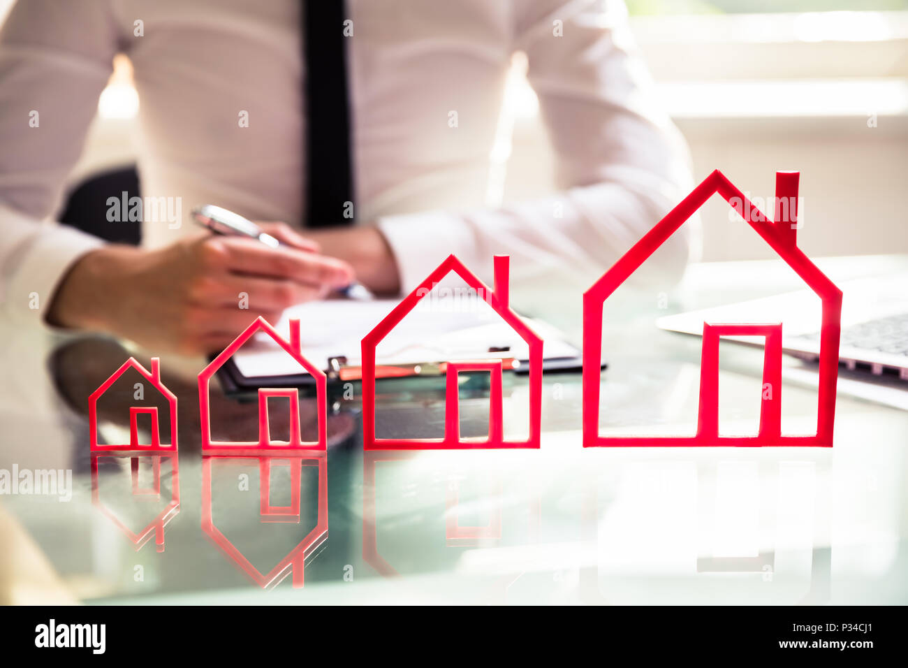 Red Outline Of Growing Houses In A Row On Reflective Desk Stock Photo ...