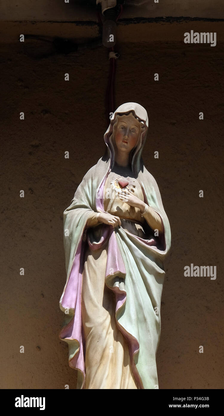 Statue of the Virgin Mary over the entrance door to the house in Lucca ...