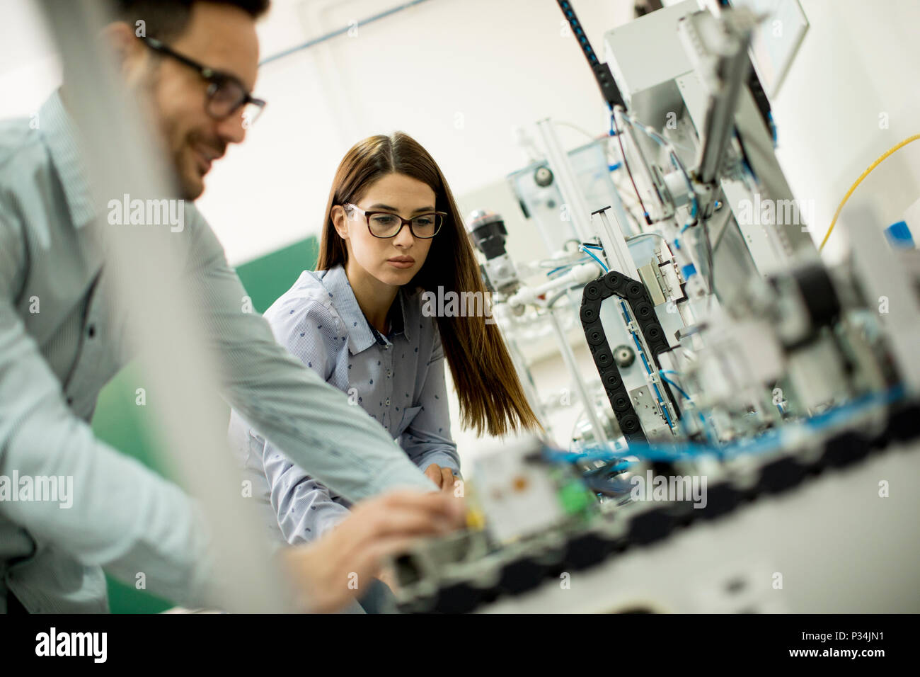Portrait of young couple of students working at robotics lab Stock ...