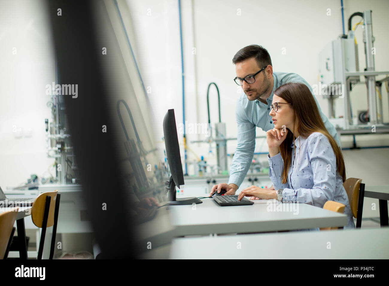 Side view of focused students using desktop pc in classroom at ...