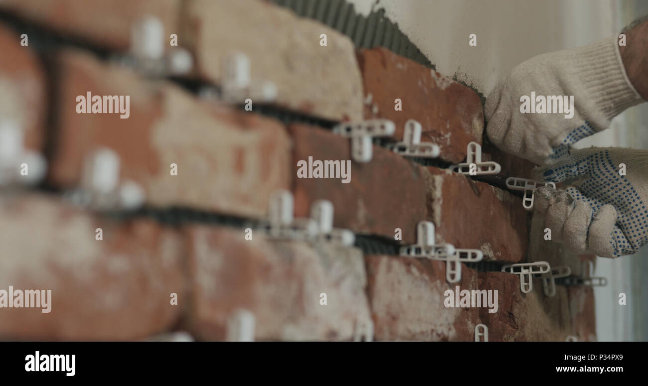 closeup worker applying brick cuts tile to the wall, wide photo Stock ...