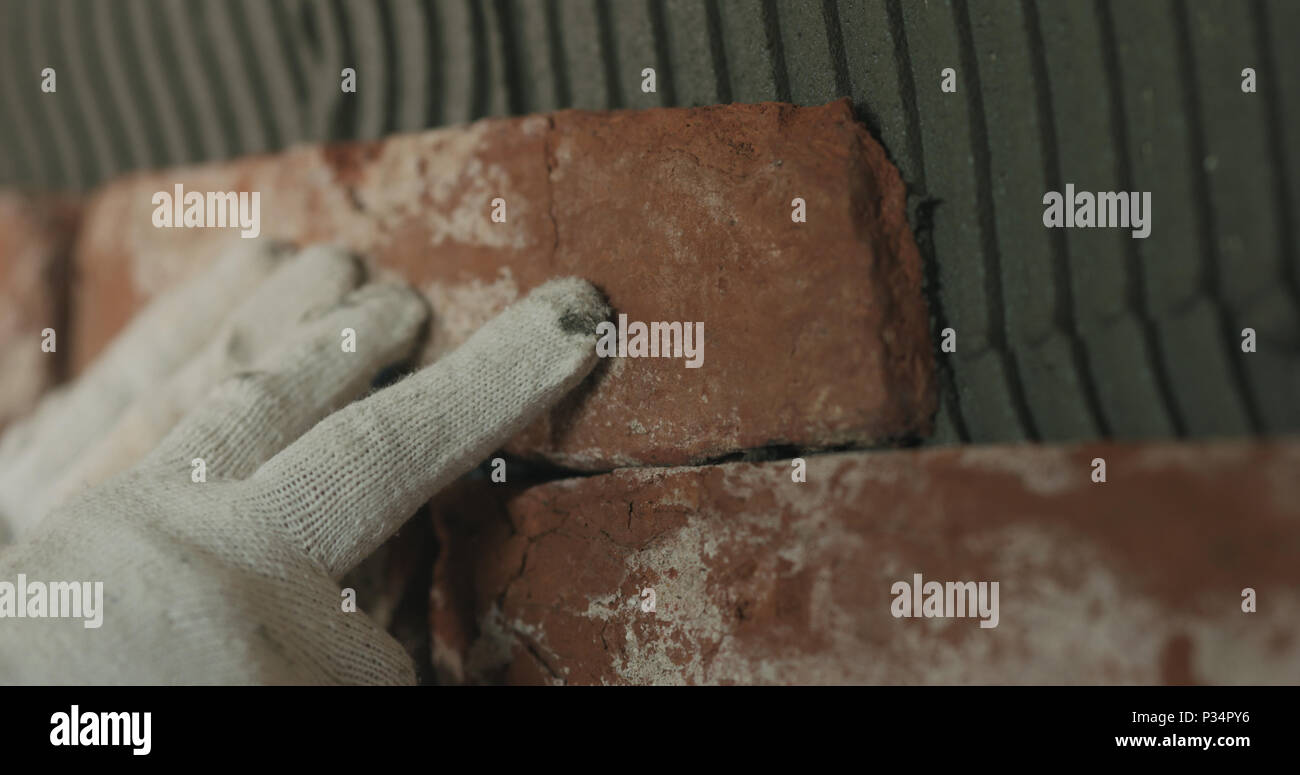 closeup worker applying brick cuts tile to the wall, wide photo Stock ...
