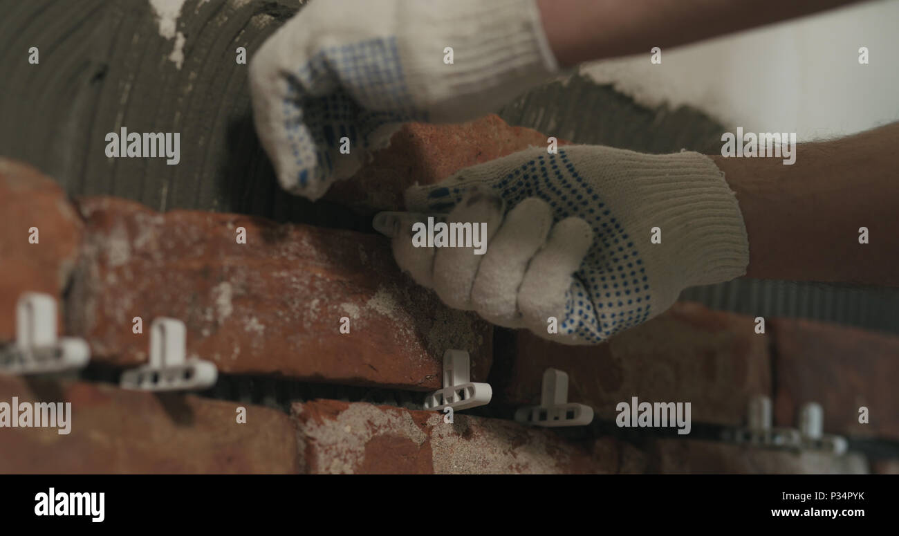 closeup worker applying brick cuts tile to the wall, wide photo Stock ...