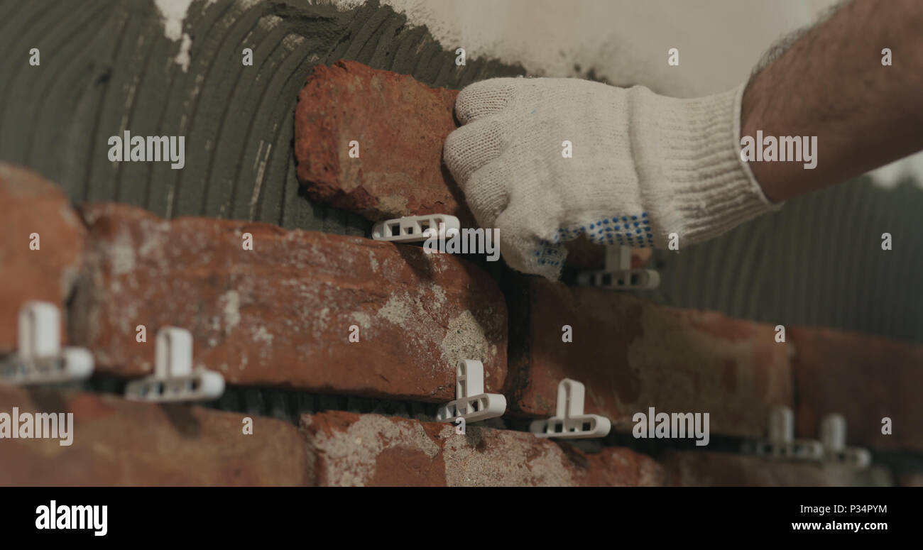 closeup worker applying brick cuts tile to the wall, wide photo Stock ...