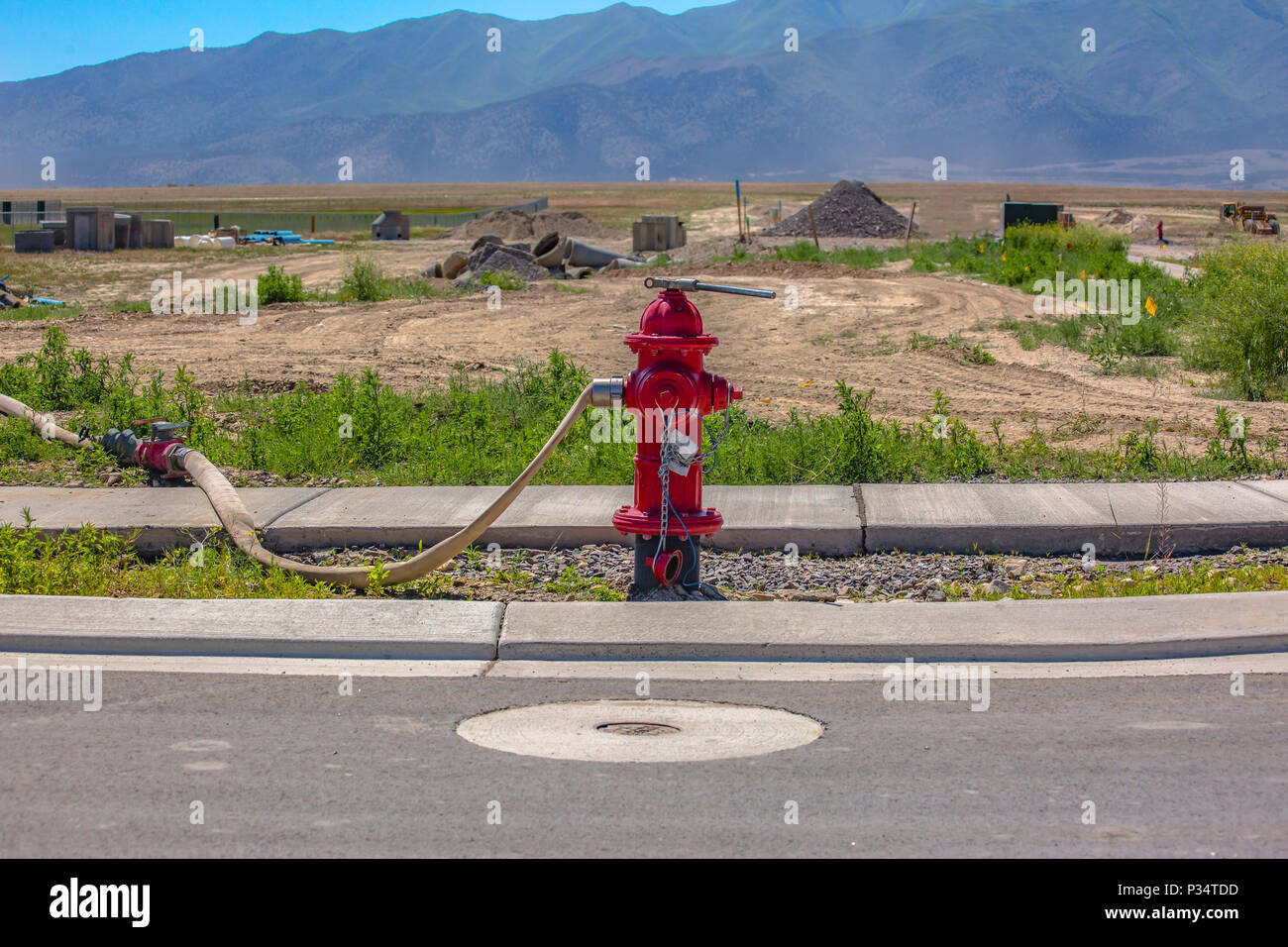 Red fire hydrant with hose connected for use in construction zone in ...