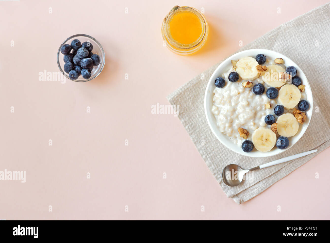 Oatmeal porridge with walnuts, blueberries and banana in bowl on pink ...