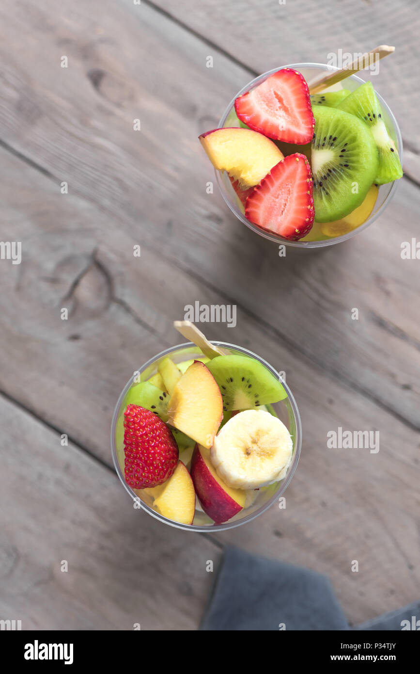 Fruit salad in plastic cups takeaway. Sliced organic fruits and berries ...