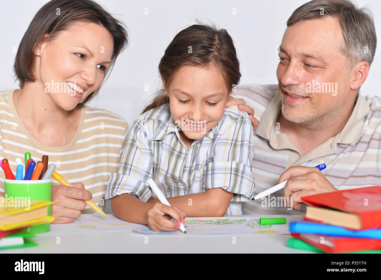 Parents with little daughter doing homework Stock Photo - Alamy