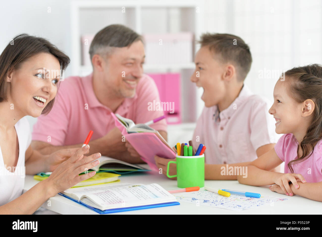 Big happy family doing homework Stock Photo - Alamy