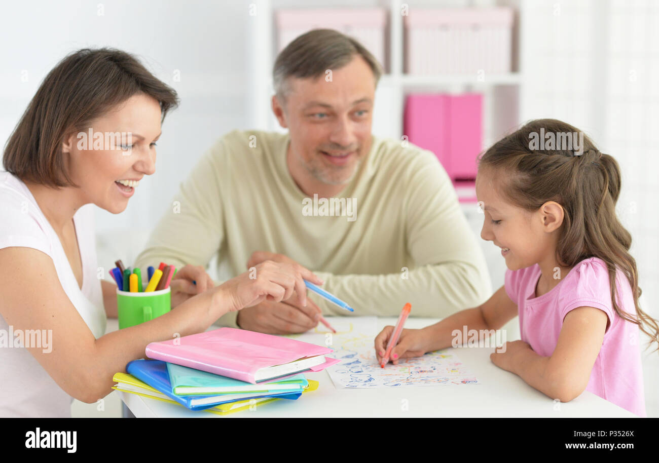 Parents and little girl doing homework Stock Photo - Alamy