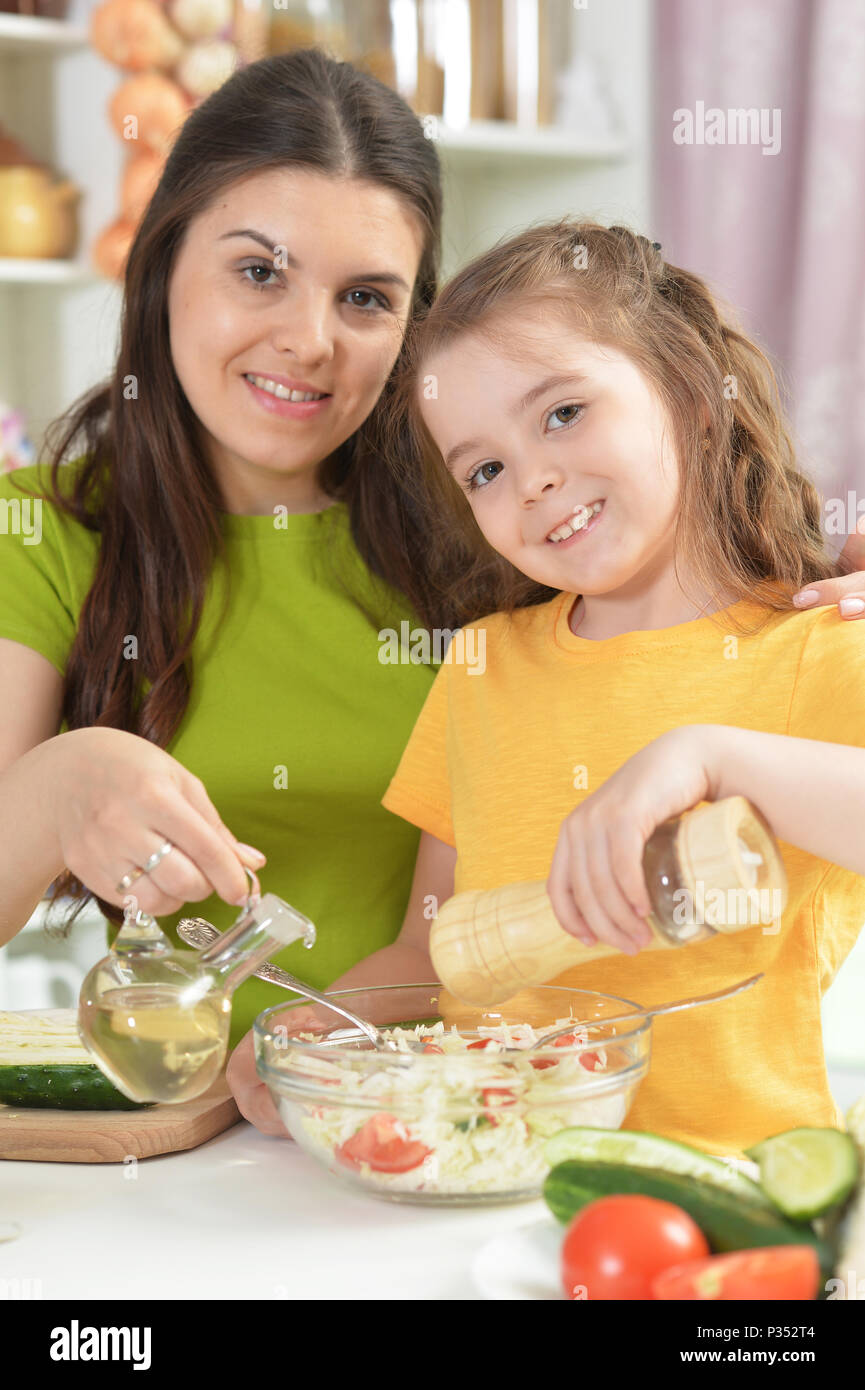 Cute little girl with her mother cooking together Stock Photo - Alamy
