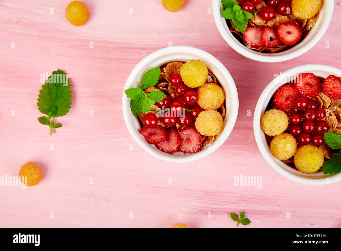 Healthy breakfast on white bowls. Fresh granola, muesli or cereal with ...