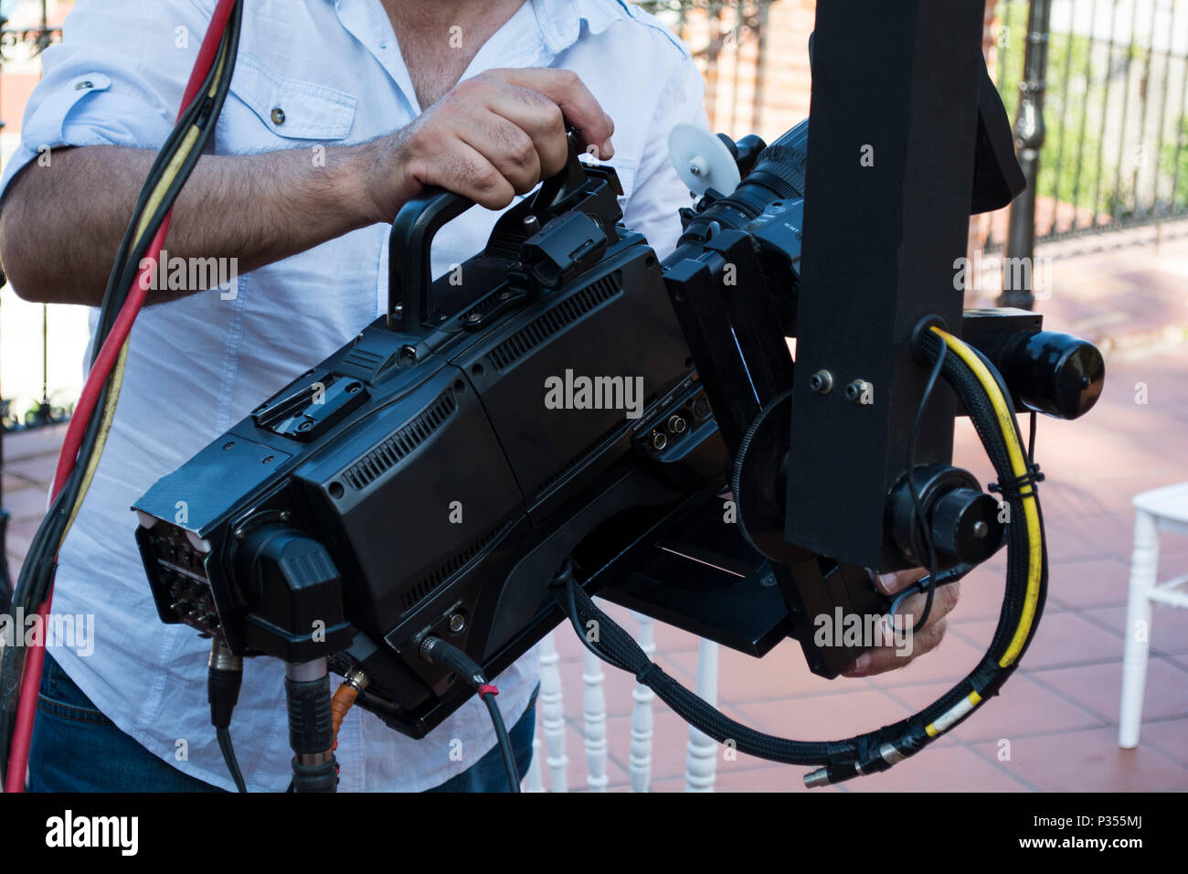 Cameraman checking equipment of camera in broadcast television green ...