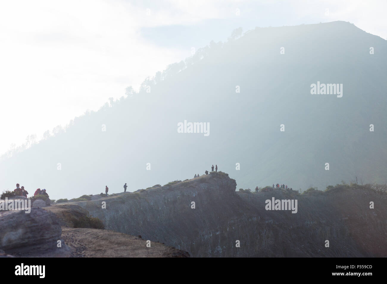Hikers walk along the rim of the Ijen volcano crater on Java, Indonesia ...