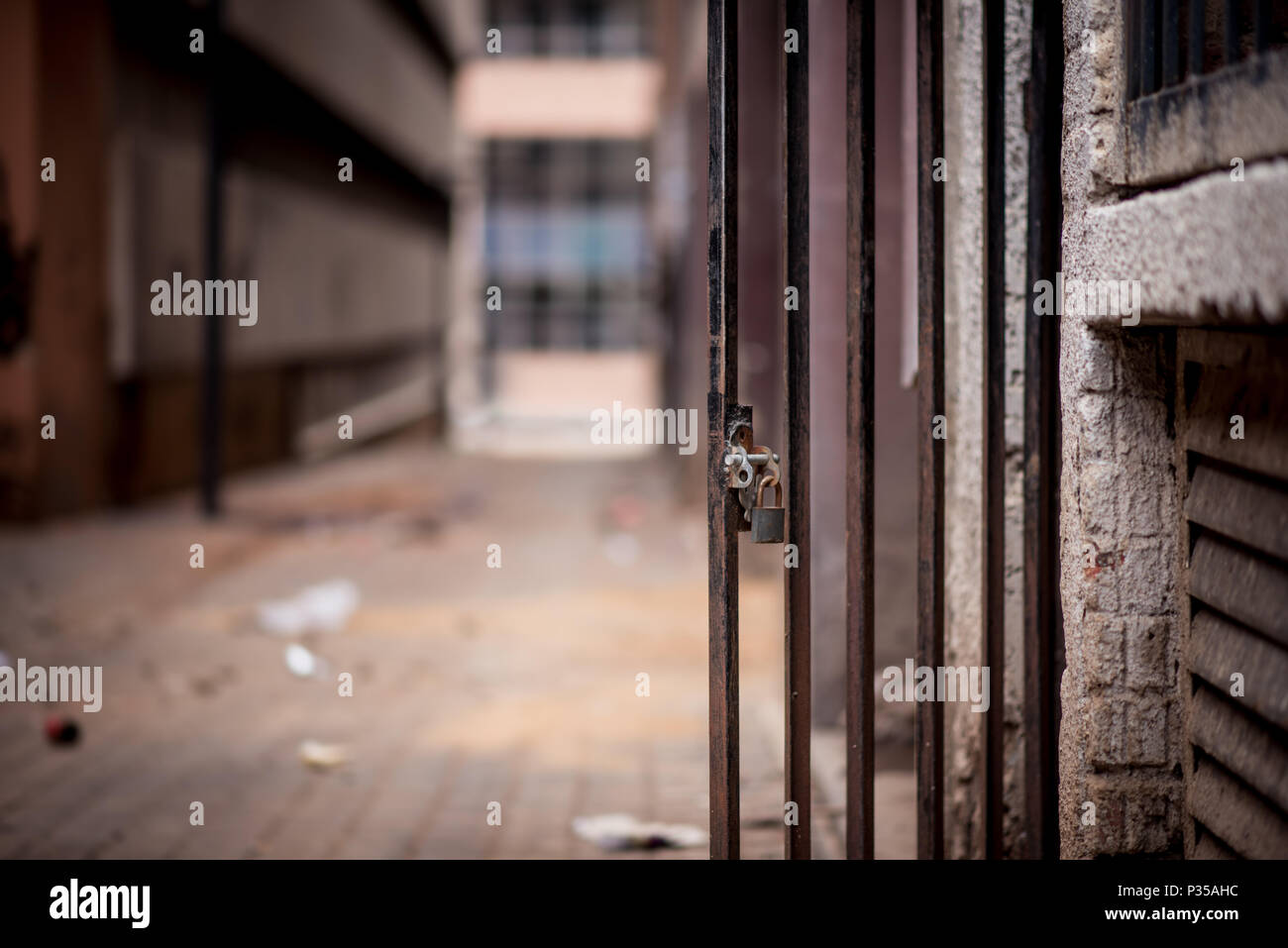 A metal barred doorway with a padlock standing open against the ...