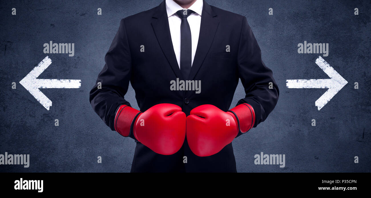 A confident businessman standing with red boxing gloves on his hand in ...