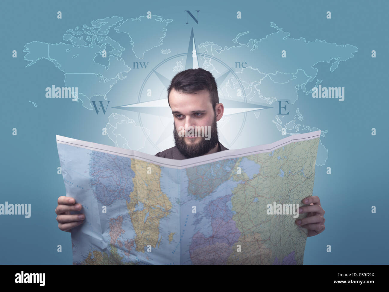 Handsome young man holding a map with a world map and a compass behind ...