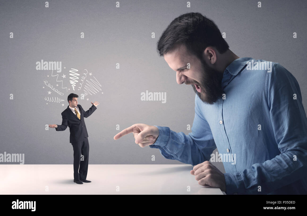 Young professional businessman being angry with an other miniature ...