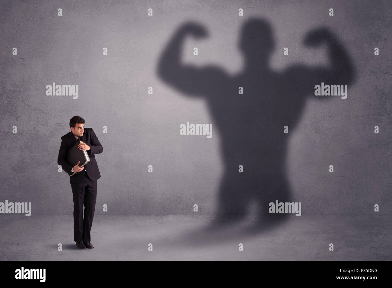 Business man looking at his own strong fit shadow concept on background ...