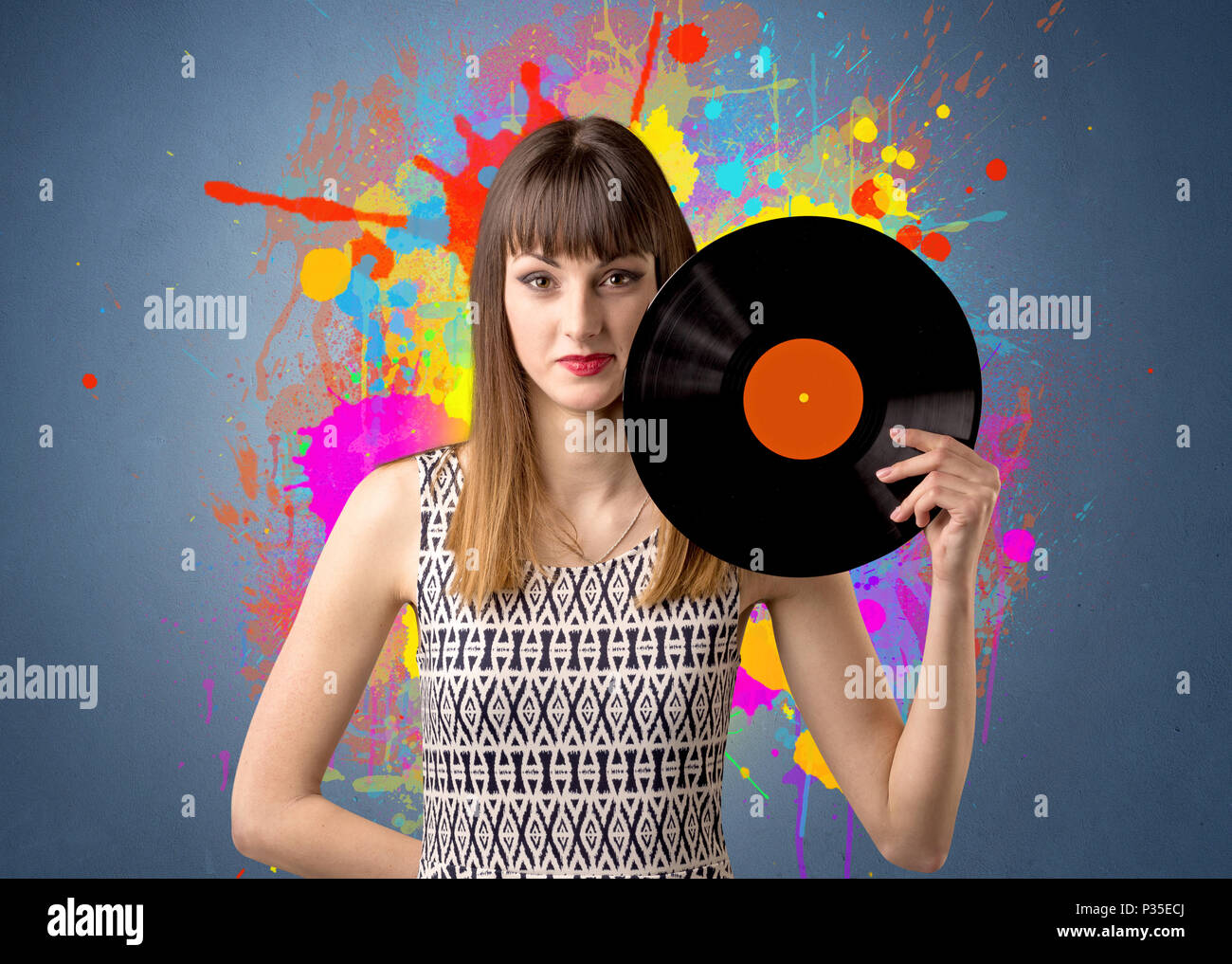 Young lady holding vinyl record on a grey background with colorful ...