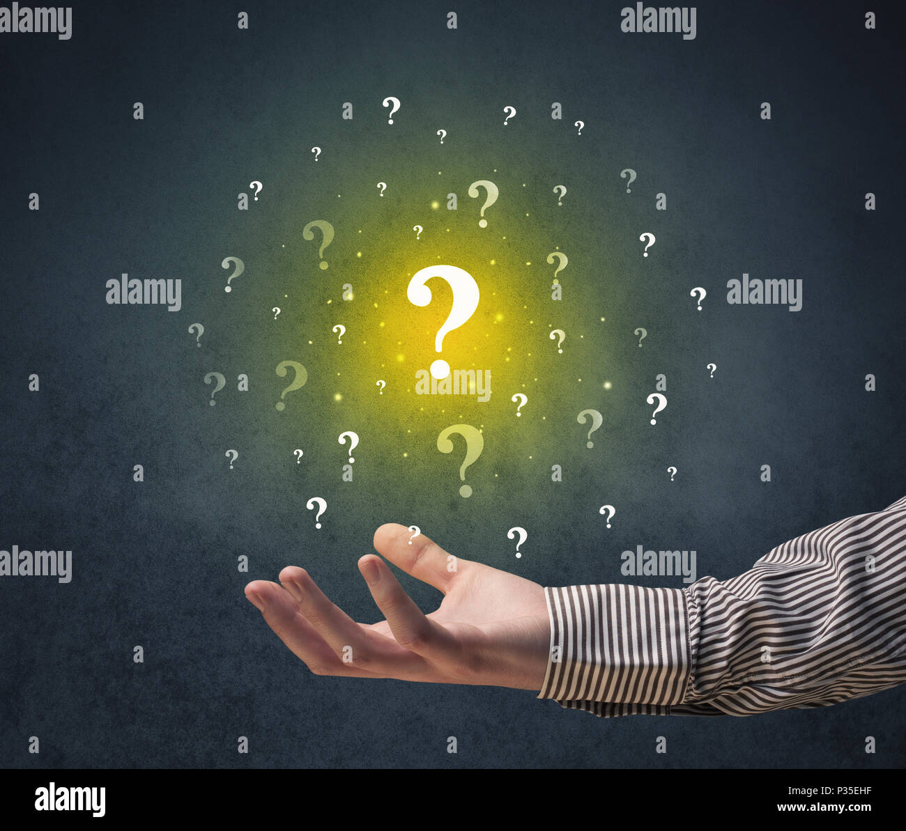 Yellow question marks hovering over young hand Stock Photo - Alamy
