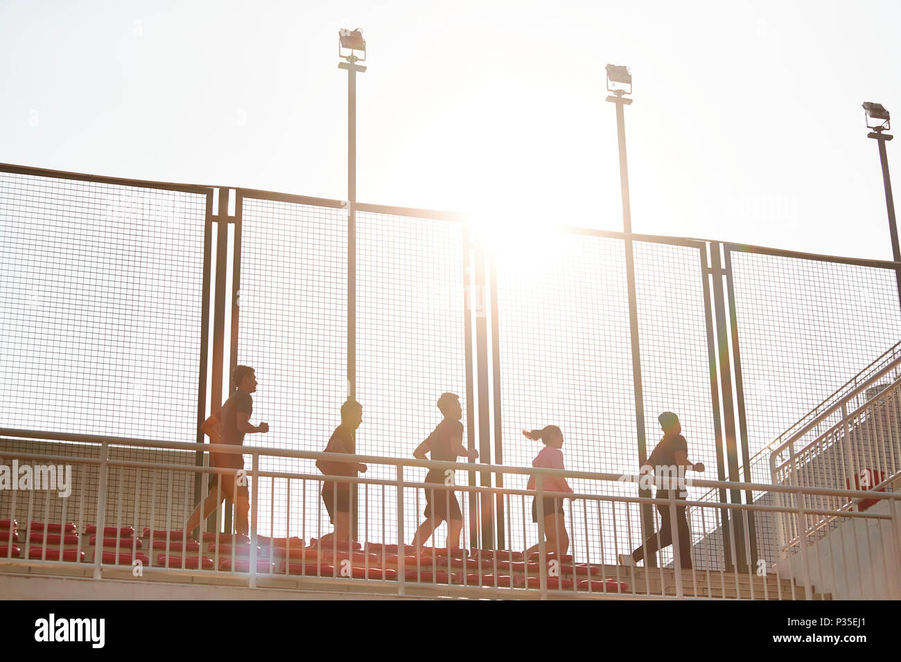 a team of young asian adult men and woman running on top of grand stand ...