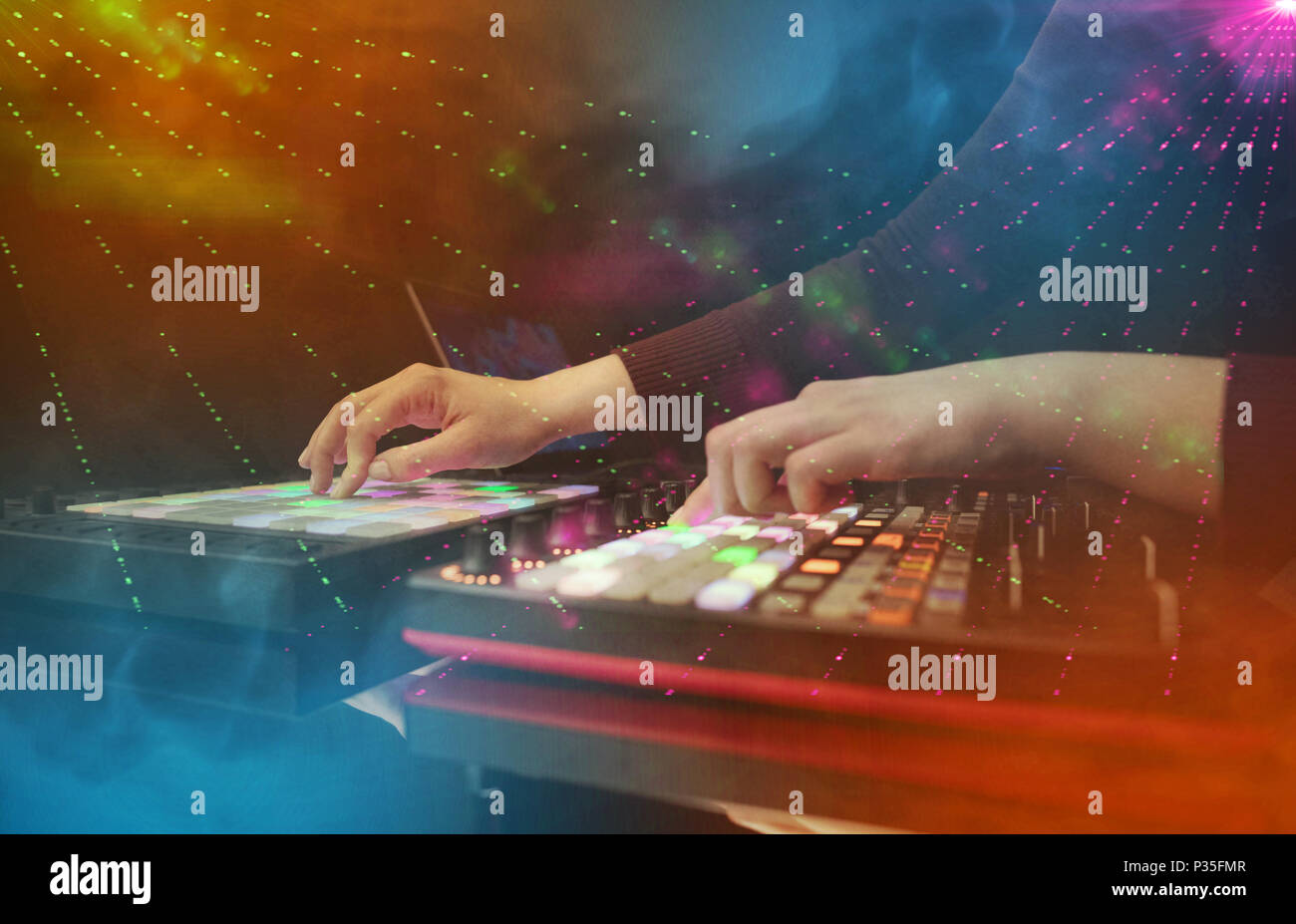 Hand mixing music on dj controller with party club colors around Stock ...