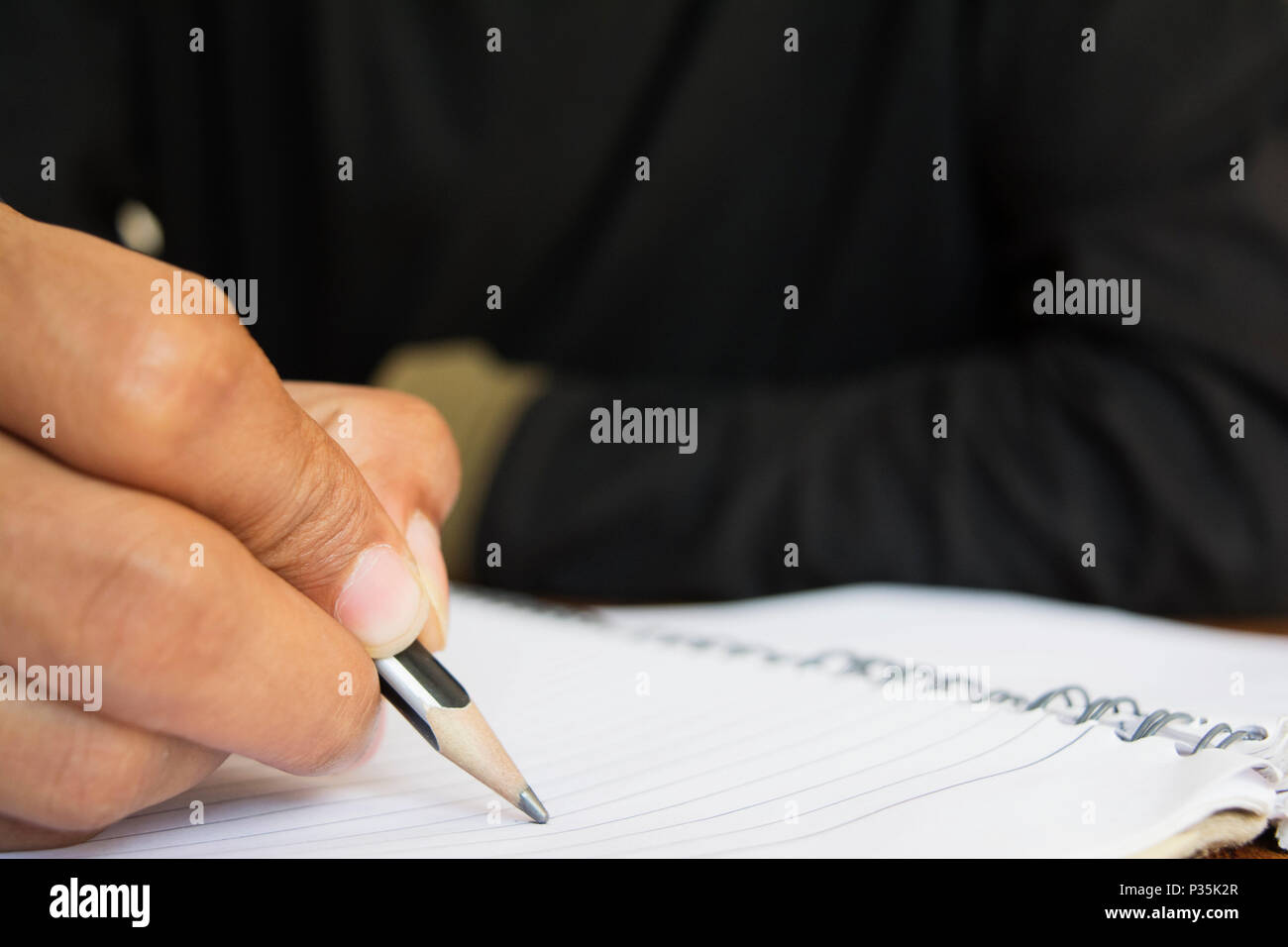 man writing a note with pencil Stock Photo - Alamy