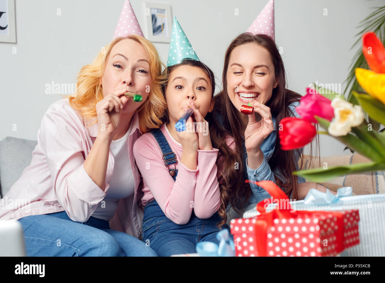 Two women and girl together at home celebrating birthday sitting on ...