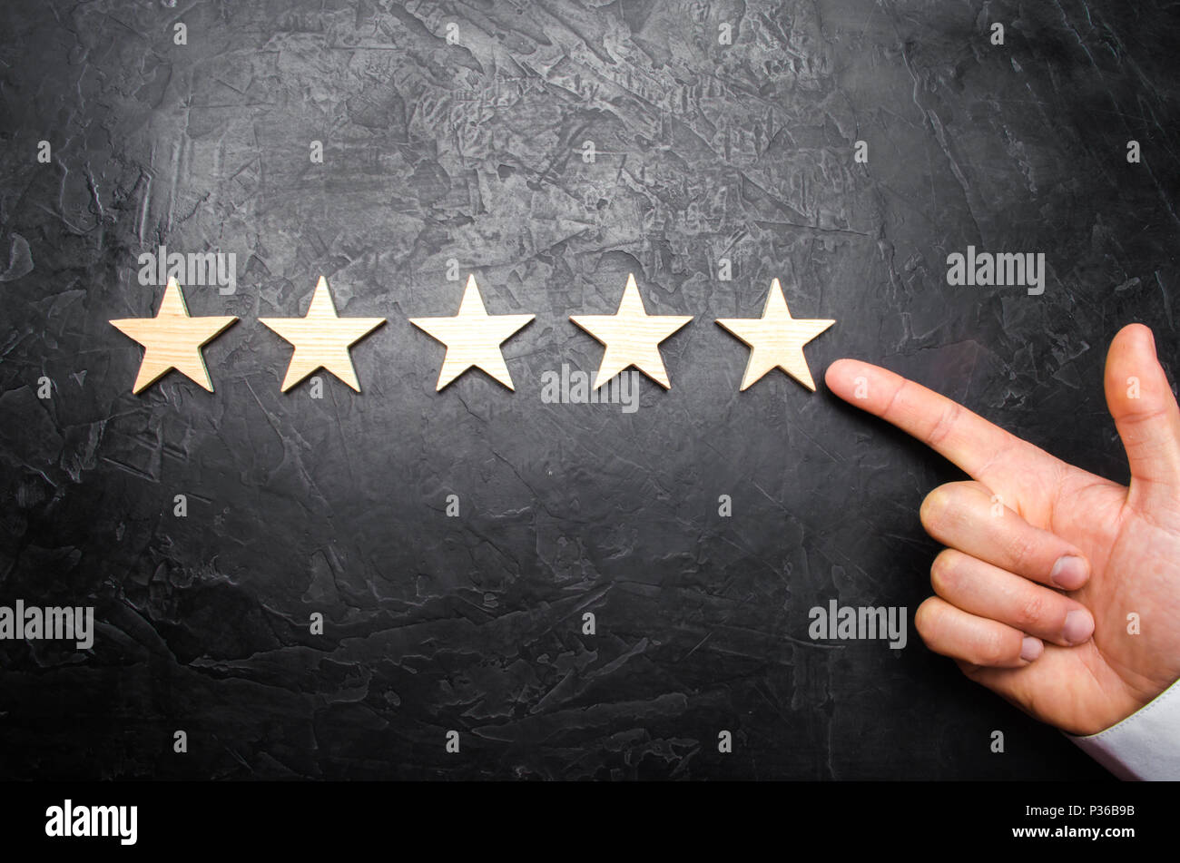 The businessman's hand in the suit points to the fifth star. Get the ...