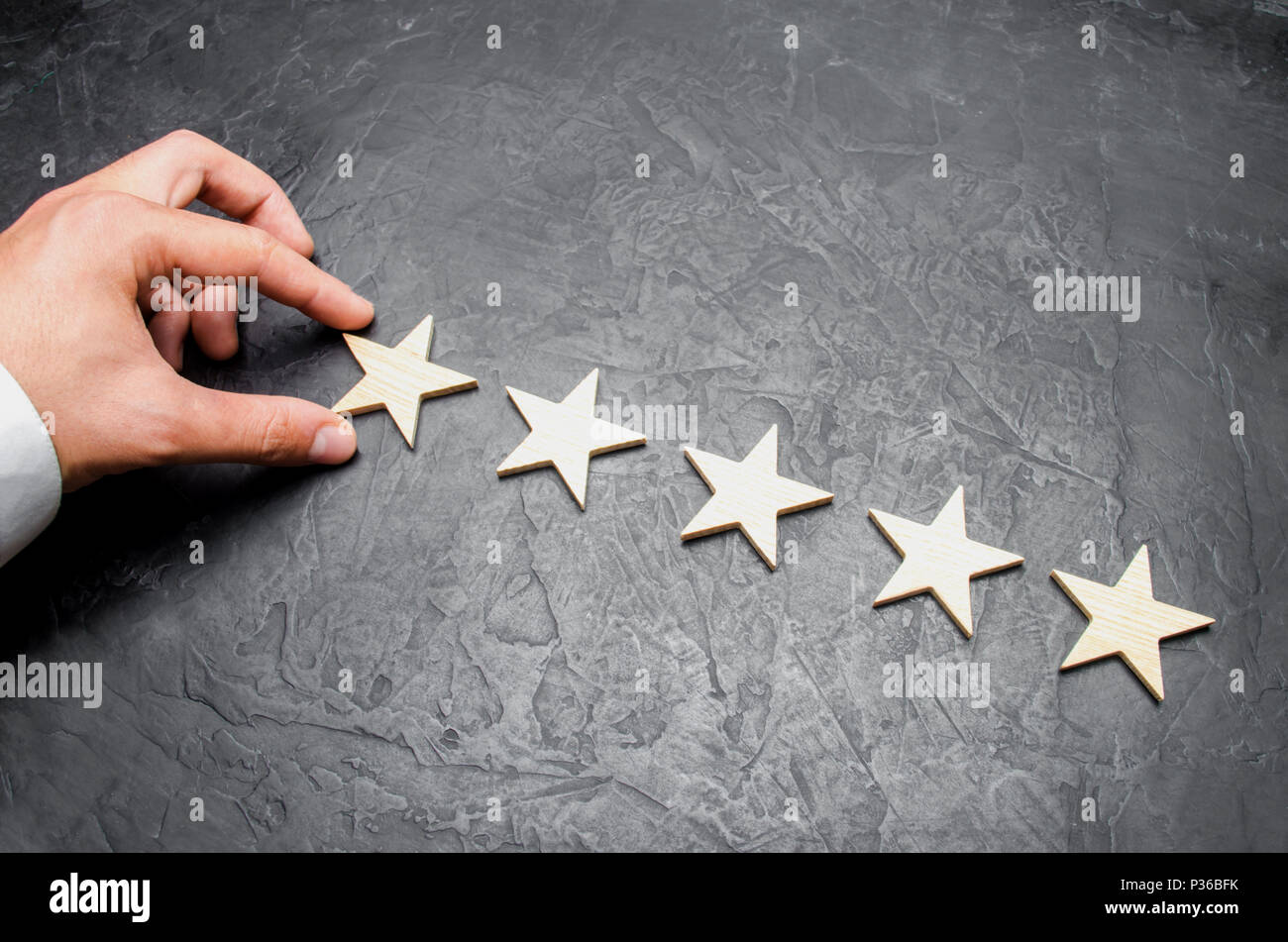 The businessman's hand in the suit holds the fifth star. Get the fifth ...