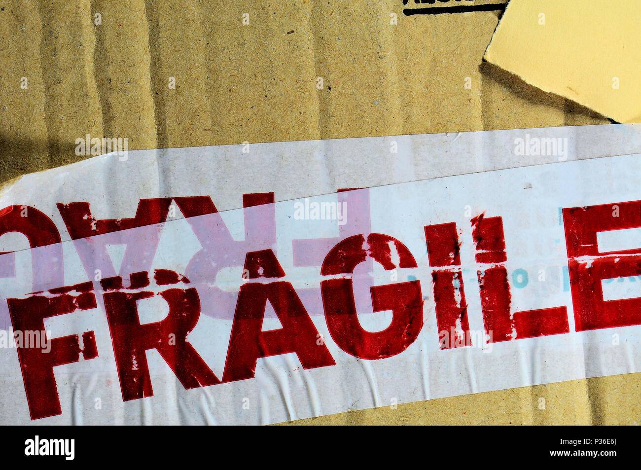 Adhesive tape with FRAGILE word on old eroded cardboard Stock Photo - Alamy