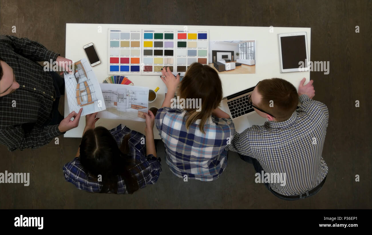 Designers talking on the phone with client while selecting colors from ...