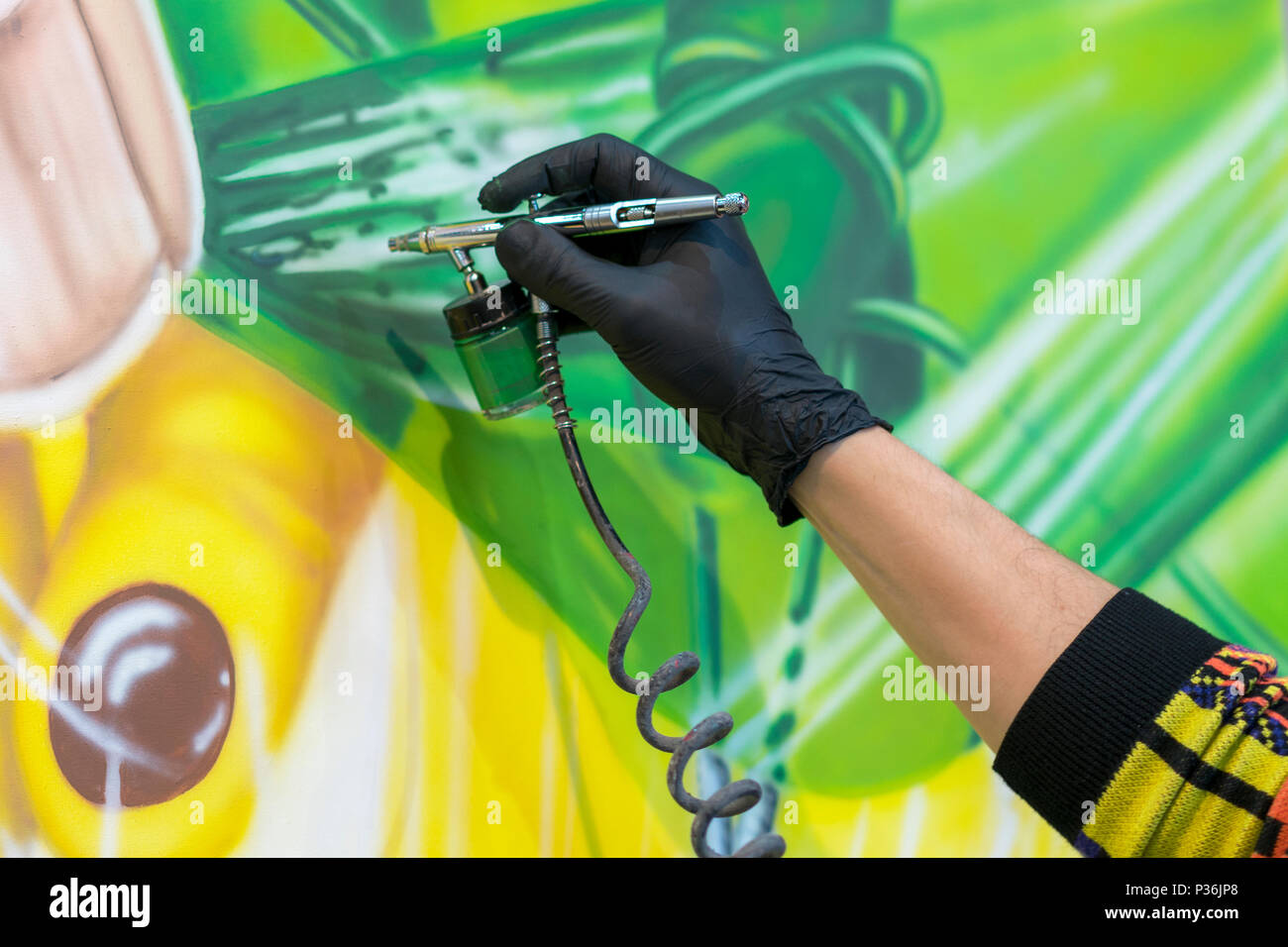 The artist paints a picture with a spray gun Stock Photo - Alamy
