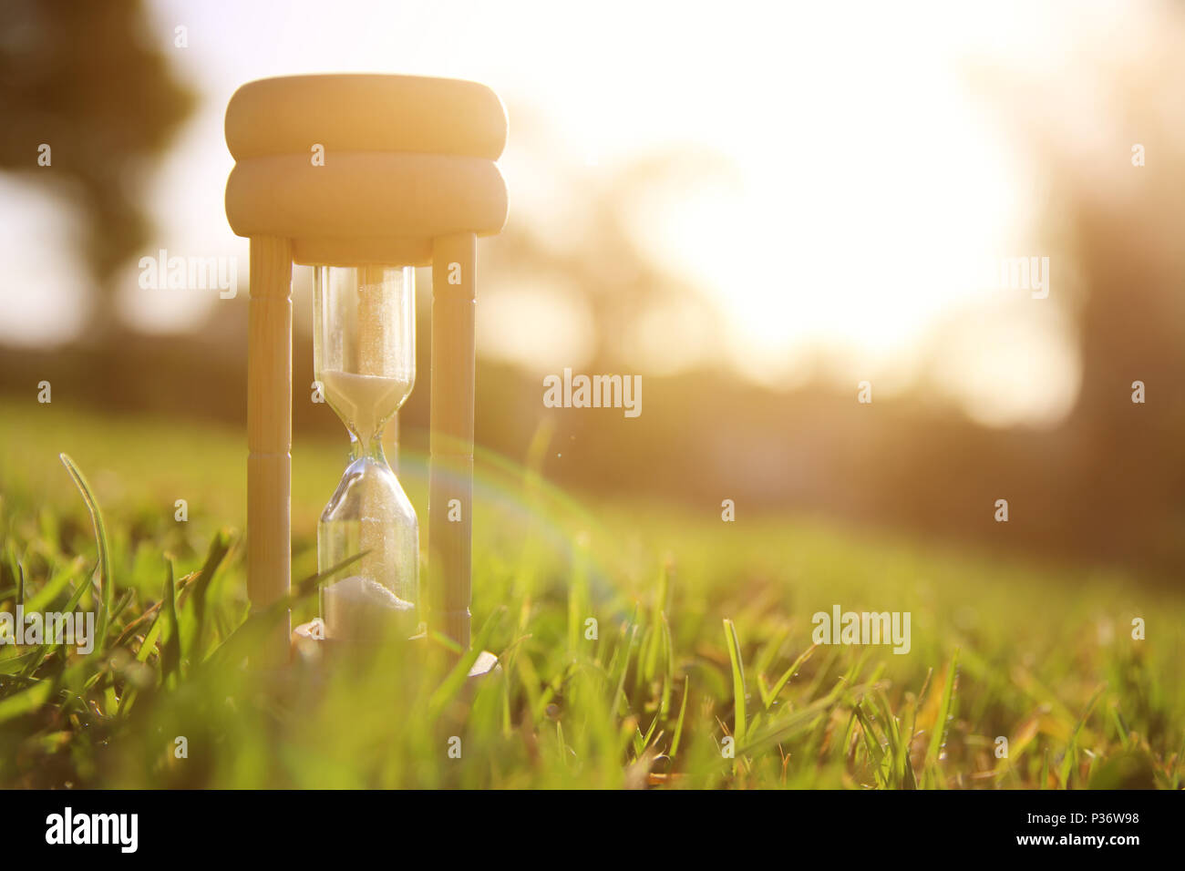 Hourglass in the grass time during sunset. vintage style Stock Photo ...
