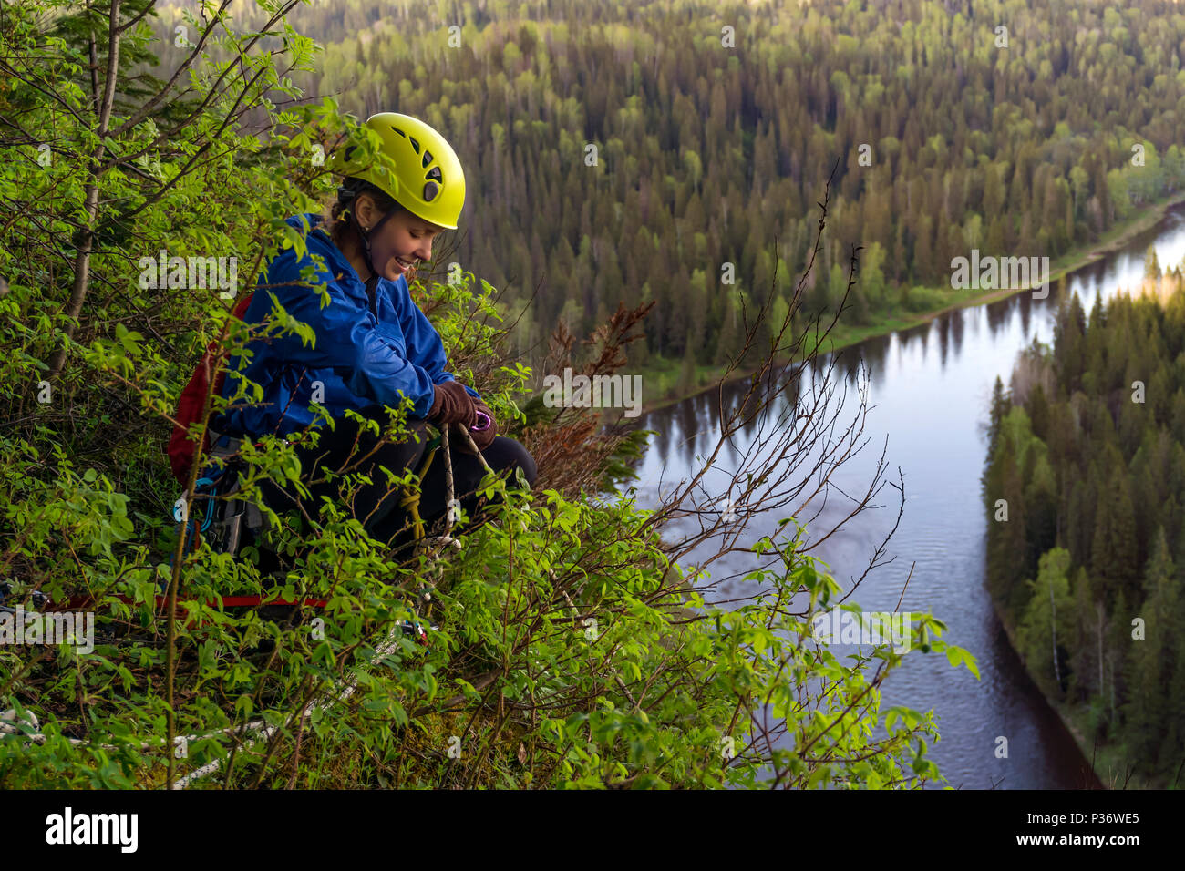 climber girl checks the safety equipment while preparing to descend ...