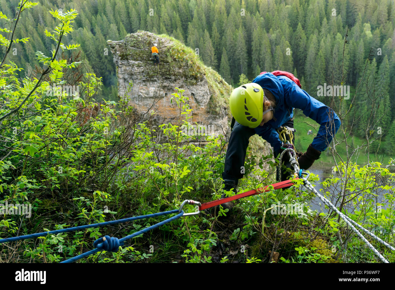 climber girl checks the safety equipment while preparing to descend ...