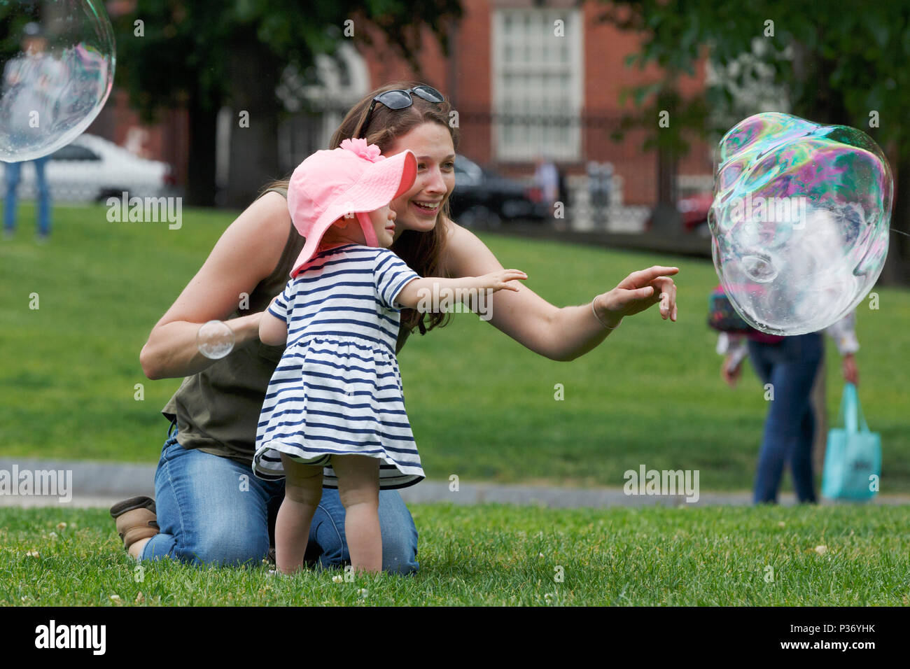 Children chasing bubbles created by a street performer on Boston Common ...