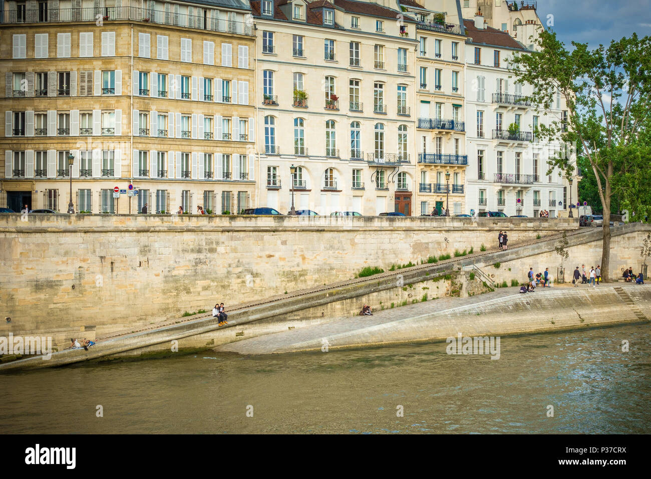 People hang out on the tip of the Île Saint-Louis at Place Louis Aragon ...